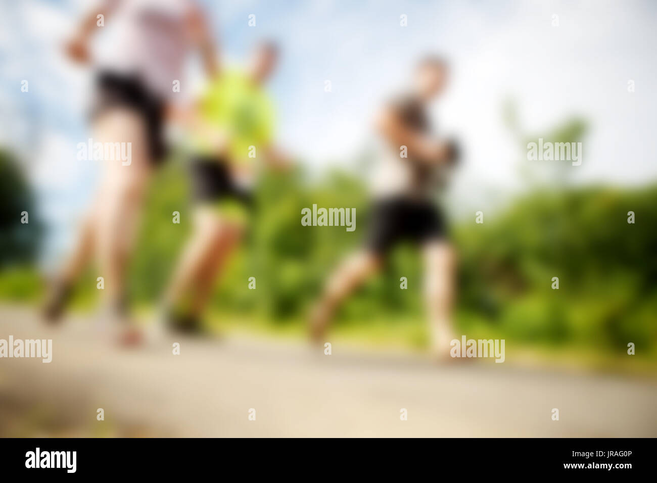blurred Photos from below running athletes on road in summer afternoon ...