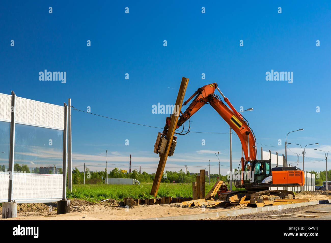 Crawler Excavator to hammer a steel piles into ground. Construction of ...
