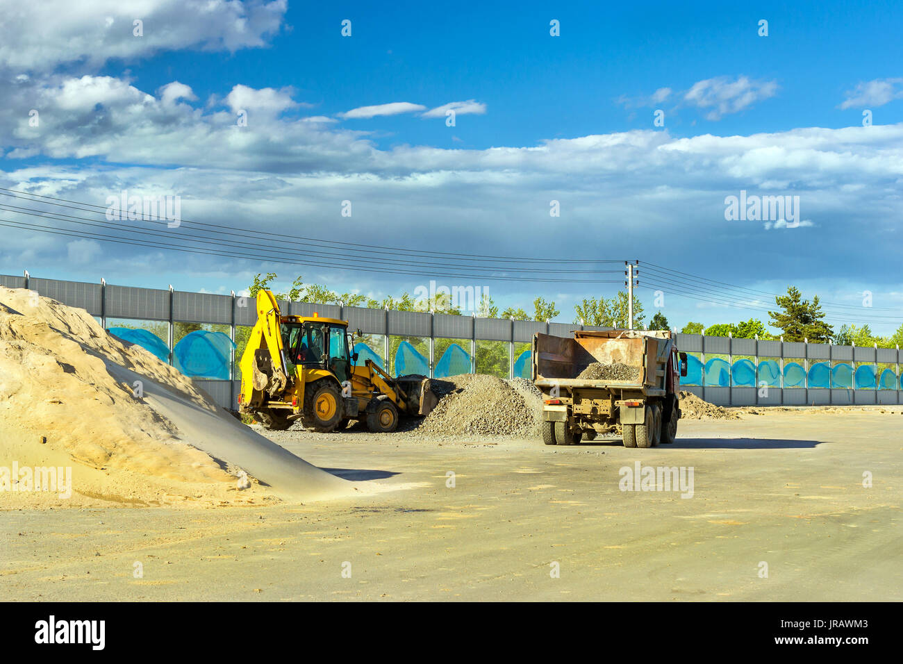 Heavy Tractor loads truck with rubble using bucket. Construction of ...
