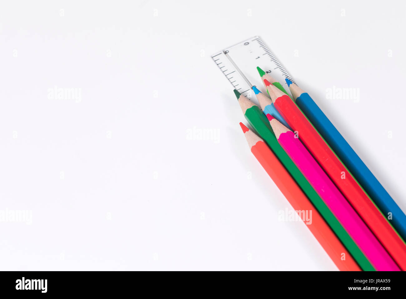 Colorful pencil crayons and ruler on white with copy space in a back to ...