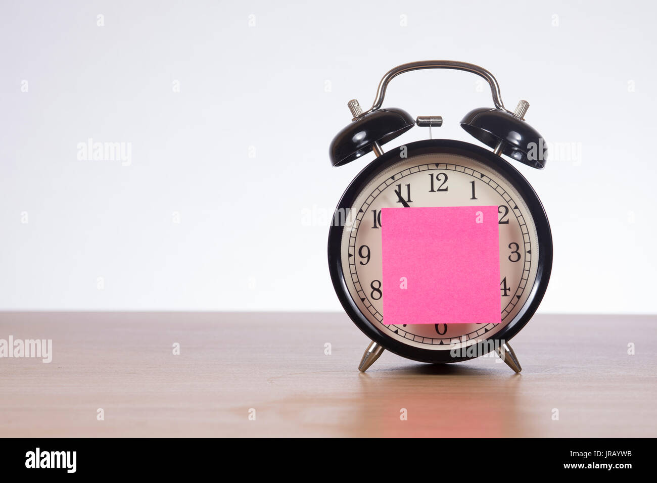 Alarm clock with sticky note against copy space plain background Stock ...