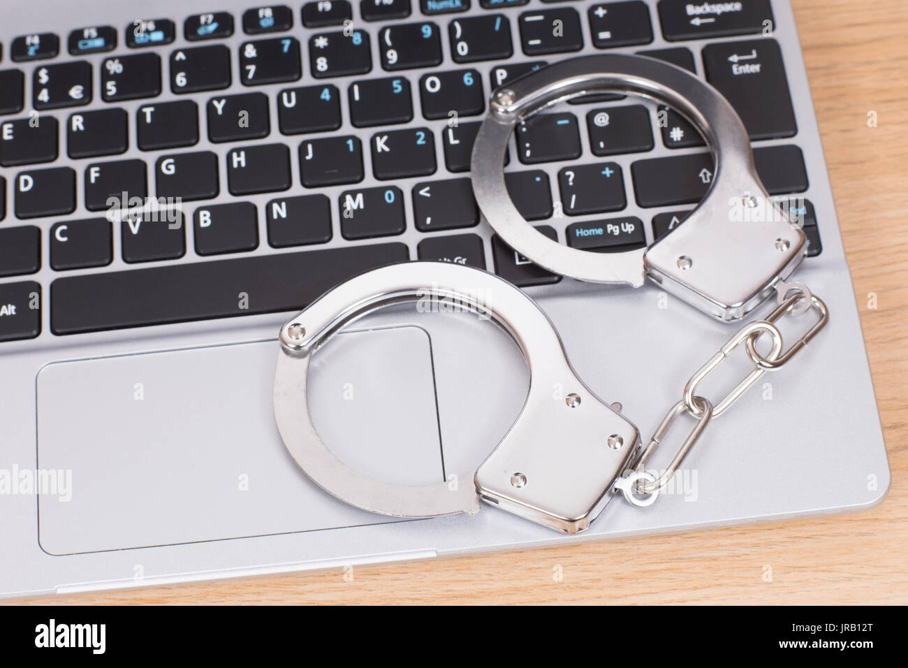 Handcuffs or manacles on a laptop computer lying on the keyboard ...