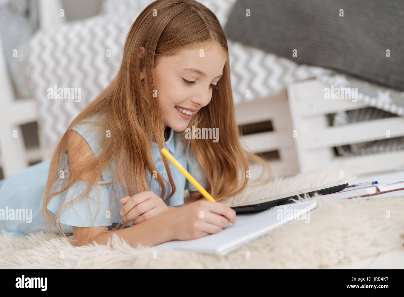 Adorable kid writing in notebook while studying at home Stock Photo - Alamy