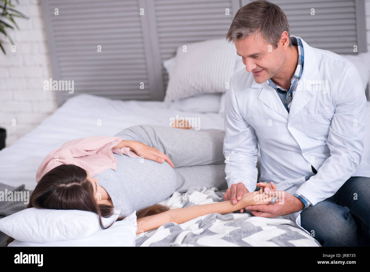 Pleased man in smock checking his patient Stock Photo - Alamy