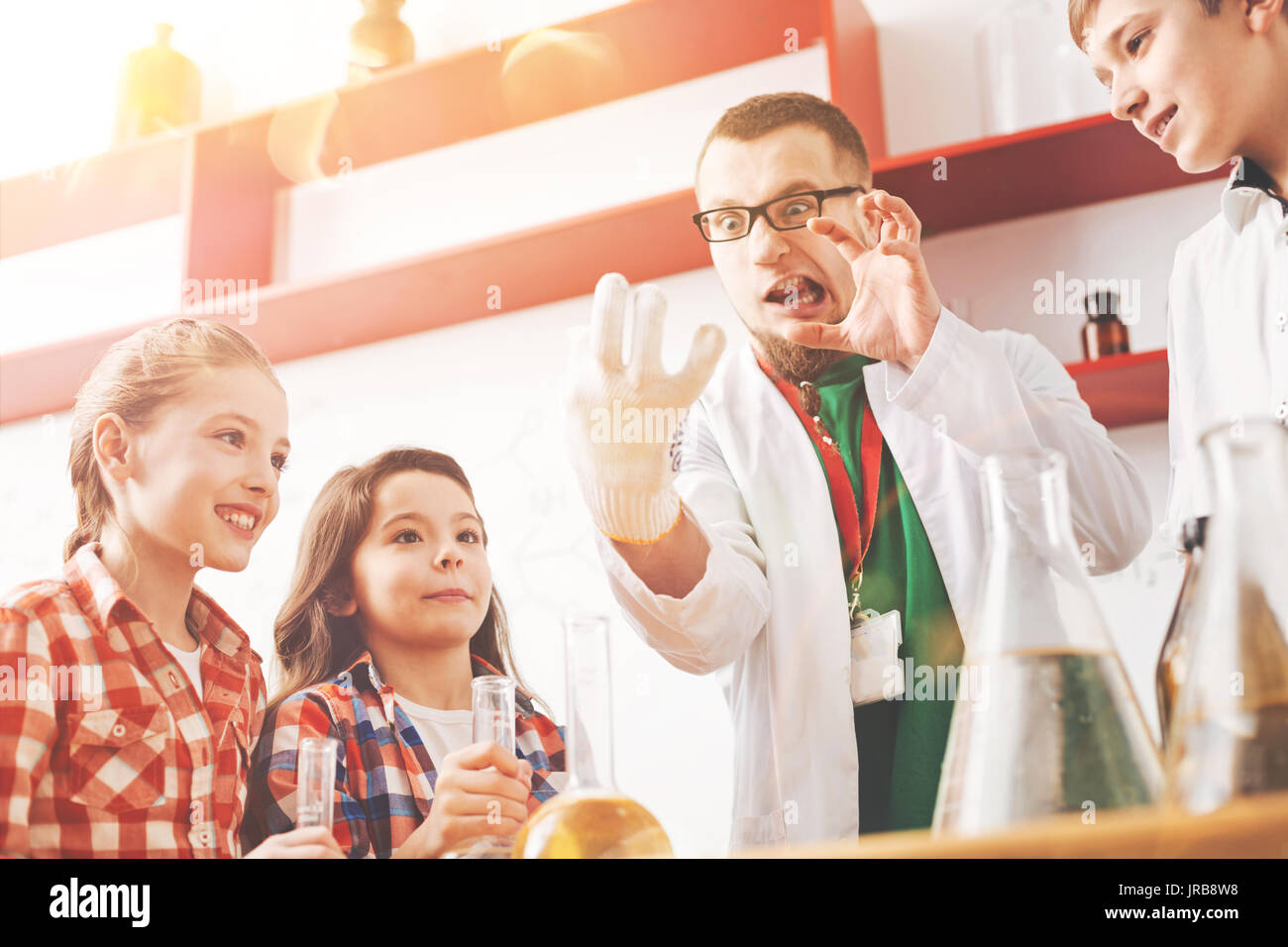 Funny teacher making faces while explaining material Stock Photo - Alamy