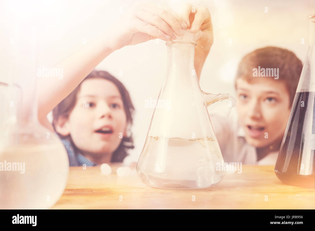 Surprised boys putting their fingers on the top of flask Stock Photo ...