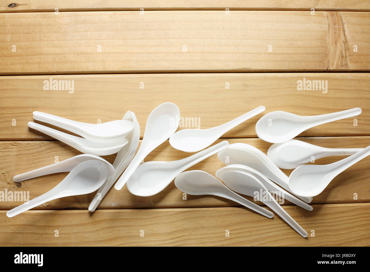 Plastic Spoons on Wooden Background Stock Photo - Alamy