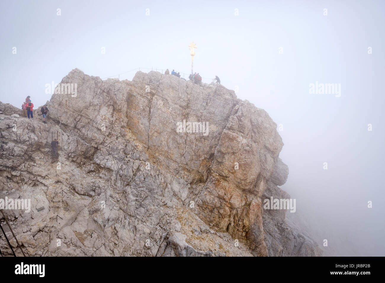 people on the Zugspitze summit by the summit cross, Bavaria, Germany ...
