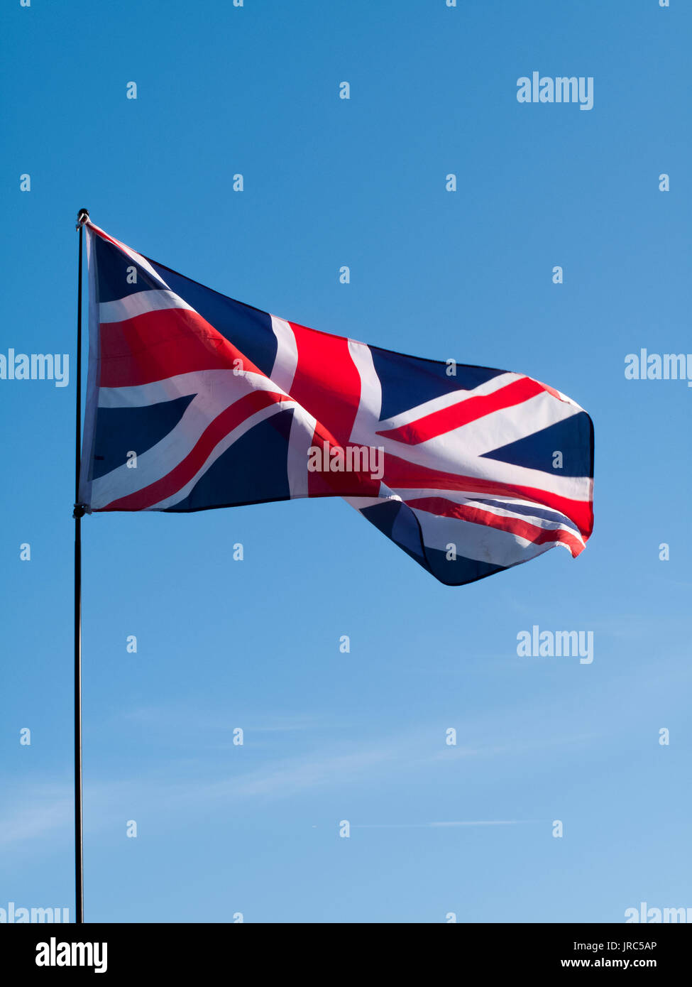United Kingdom Union Jack Flag against a clear blue sky Stock Photo - Alamy