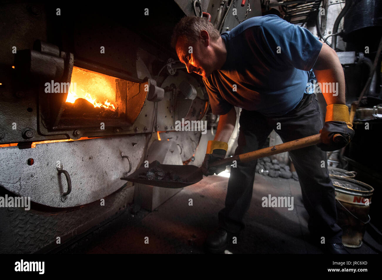Steve Loeber, a trainee Engineer Stoker, stokes the port boiler in the ...