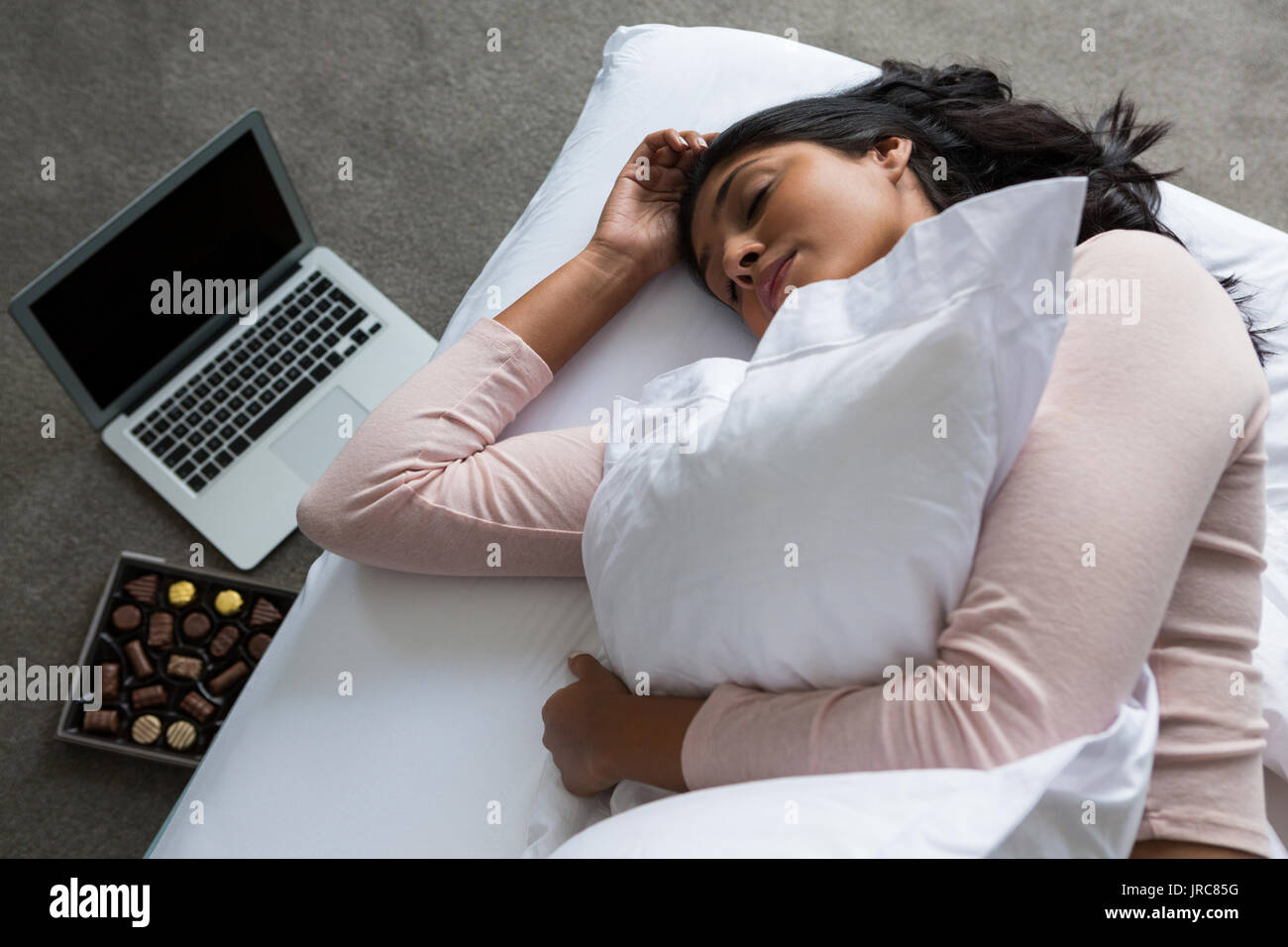 Young woman sleeping on bed over floor at home Stock Photo - Alamy