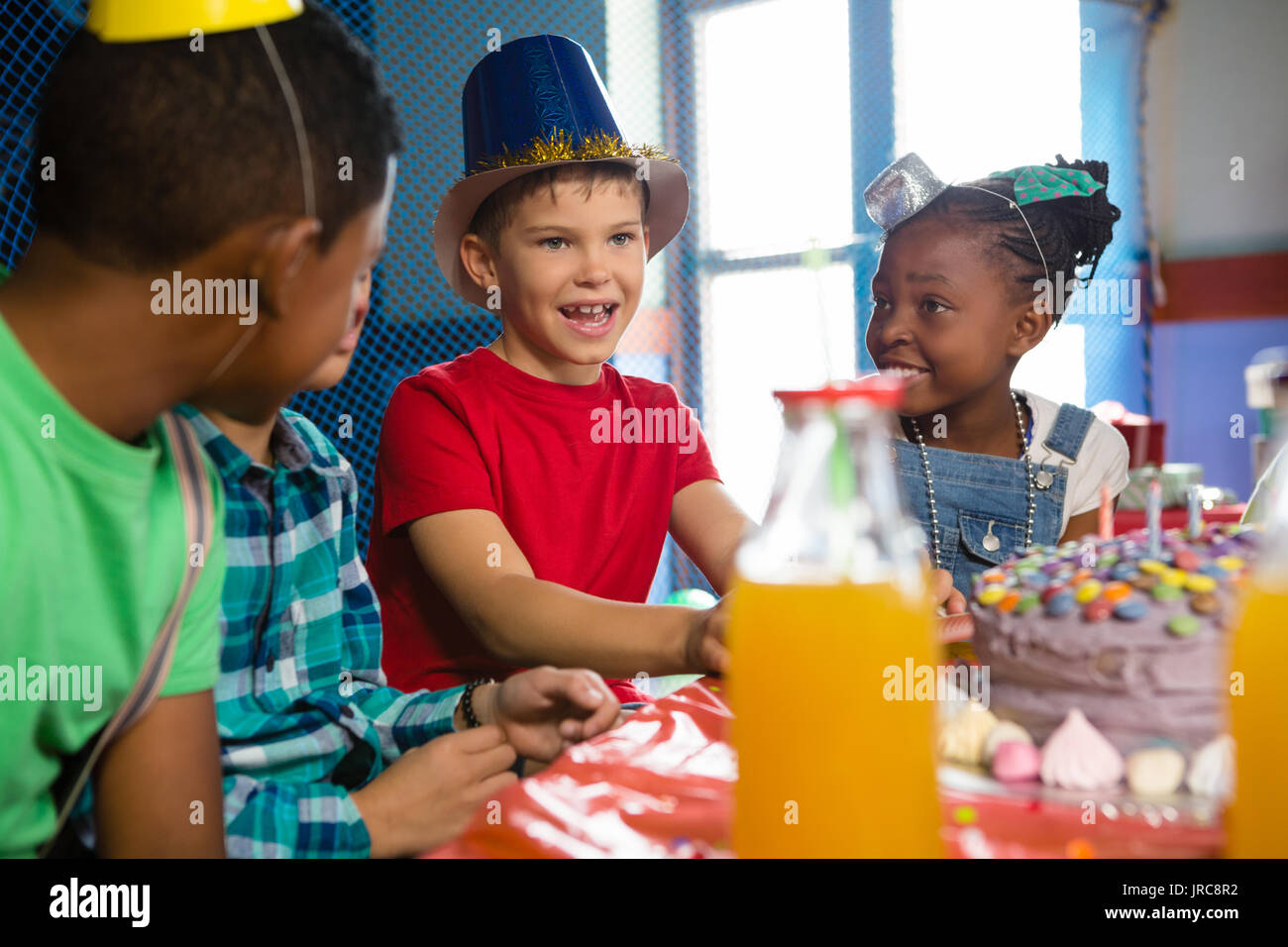 Children talking while sitting at table during birthday party Stock ...