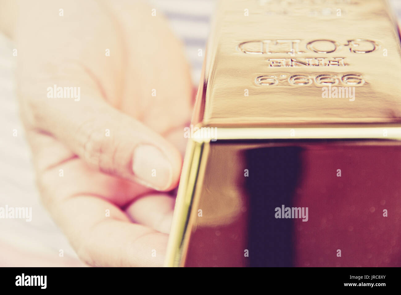 Hand hold gold bars Stock Photo - Alamy