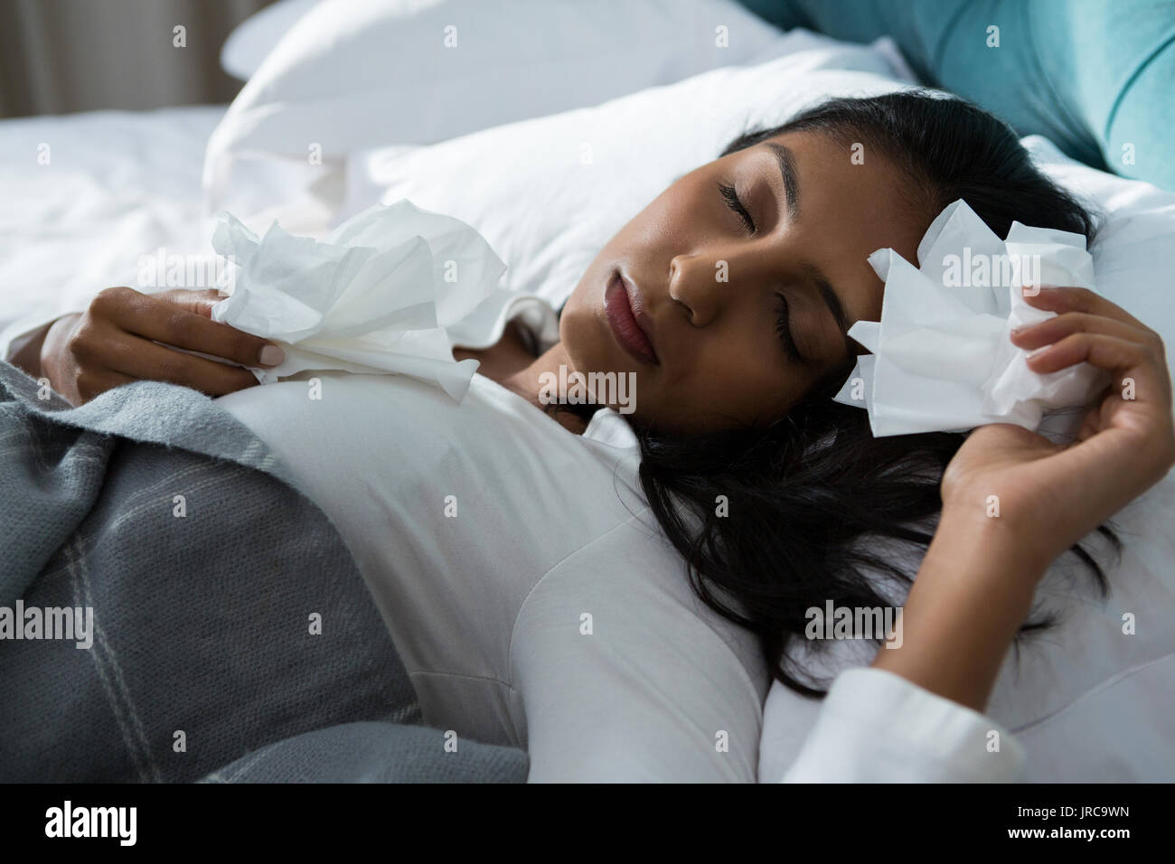 Sick young woman with tissues sleeping on bed at home Stock Photo - Alamy