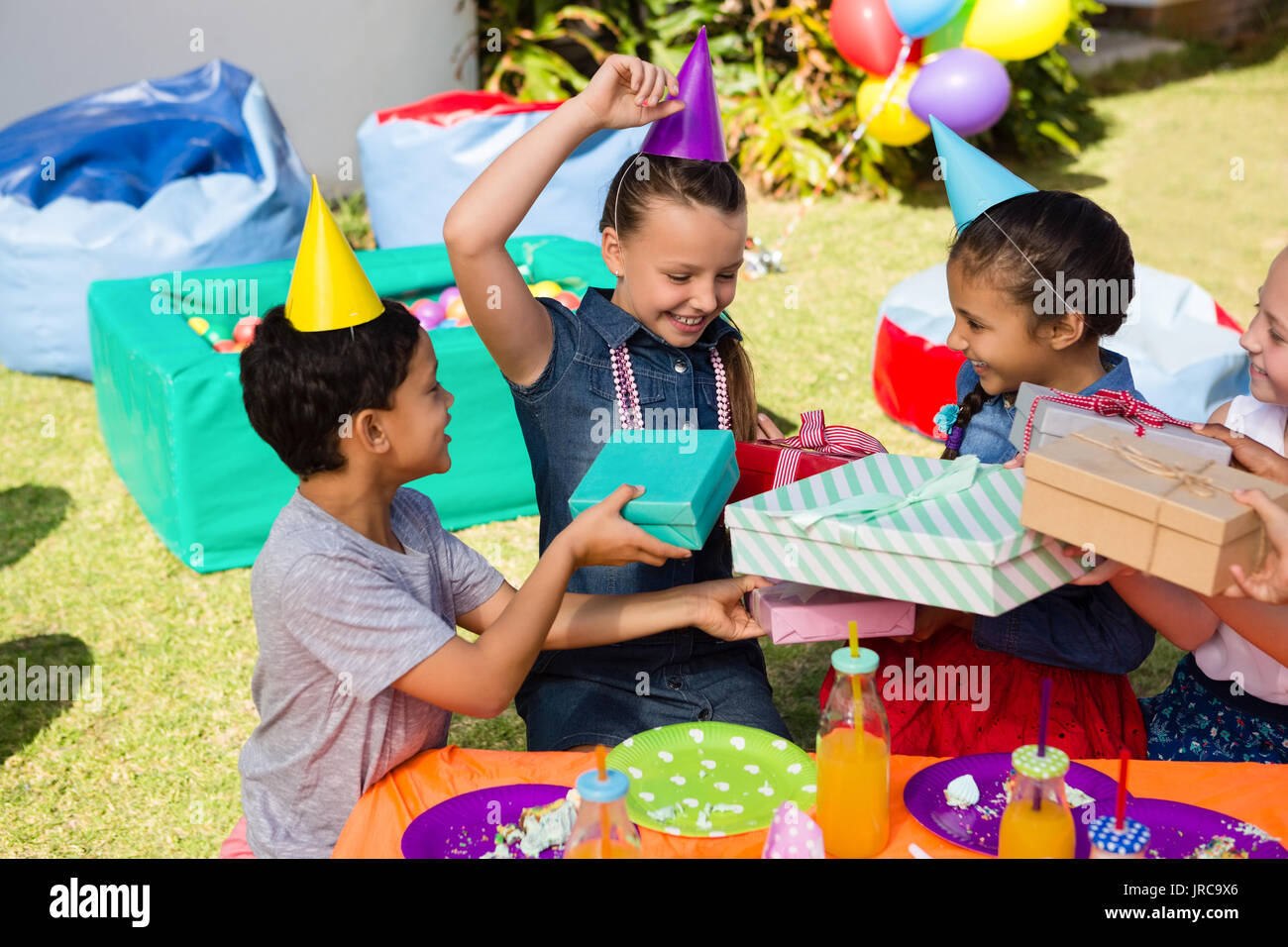 Child receiving gift from friend hi-res stock photography and images ...