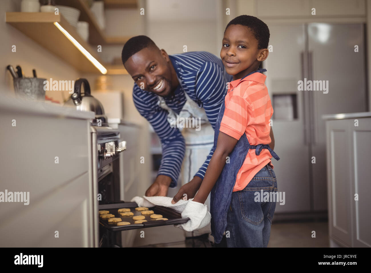 Boy baking cookies with father and oven hi-res stock photography and ...