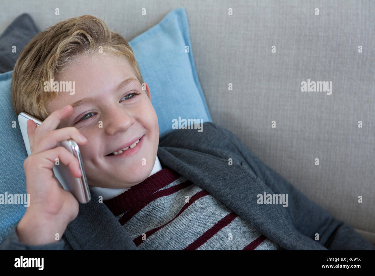 Little boy playing with phone on couch Stock Photo - Alamy