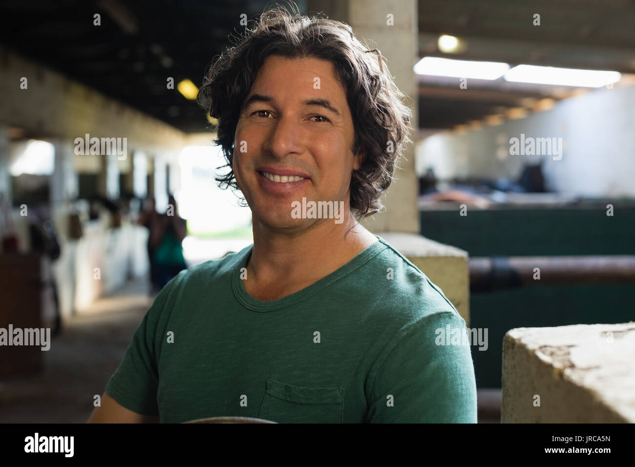Portrait of happy man standing in the stable Stock Photo - Alamy