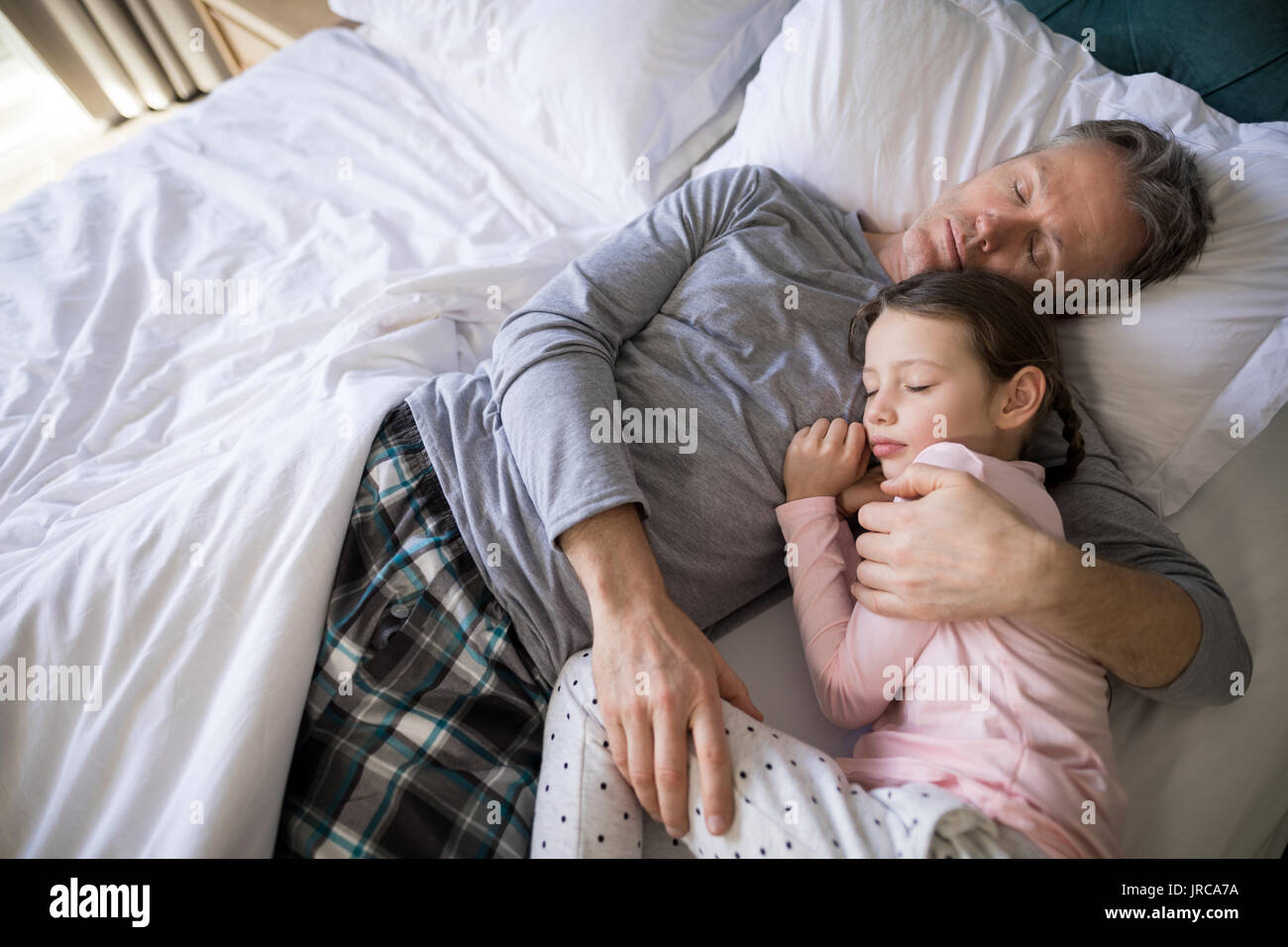 Father and daughter sleeping together on bed in bedroom at home Stock ...