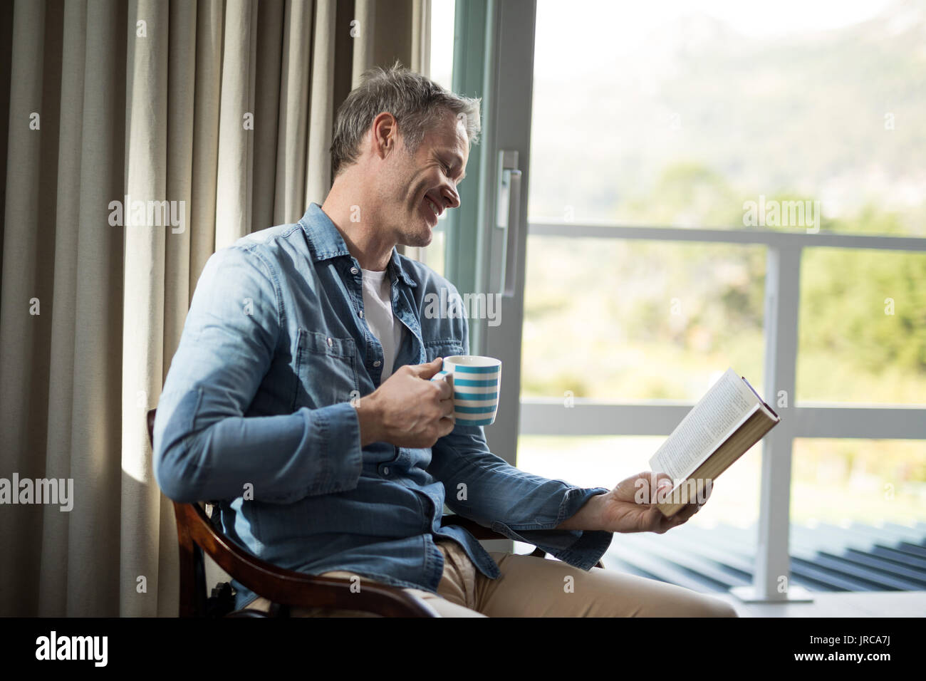 Man in chair smiling reading hi-res stock photography and images - Alamy