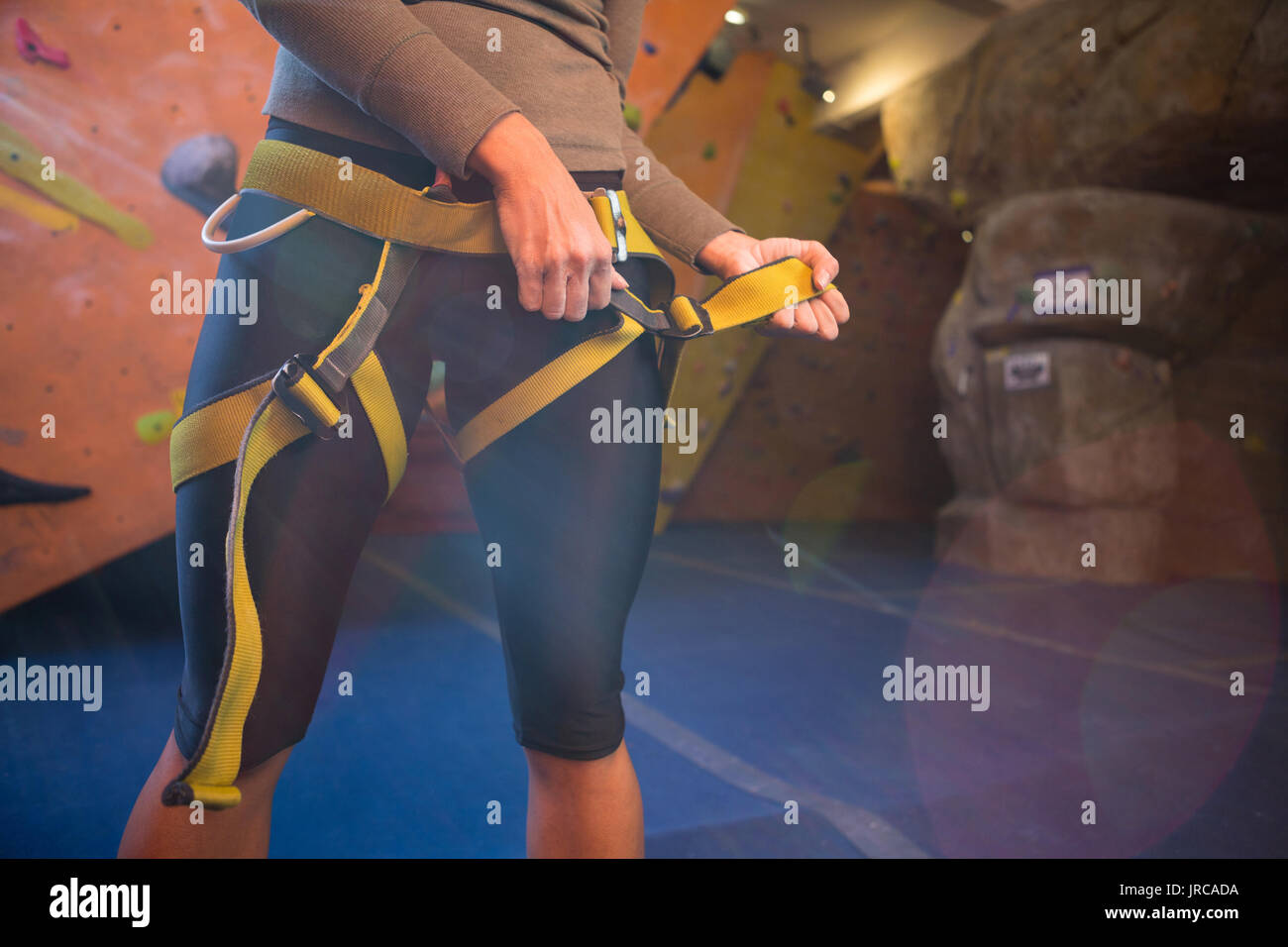 Mid section of woman wearing safety harness in fitness studio Stock ...