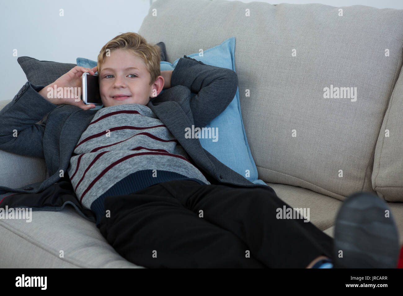 Little boy playing with phone on couch Stock Photo - Alamy