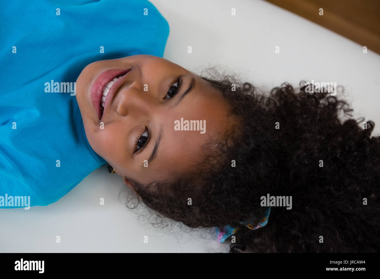 Portrait of smiling girl lying on bed in clinic Stock Photo - Alamy