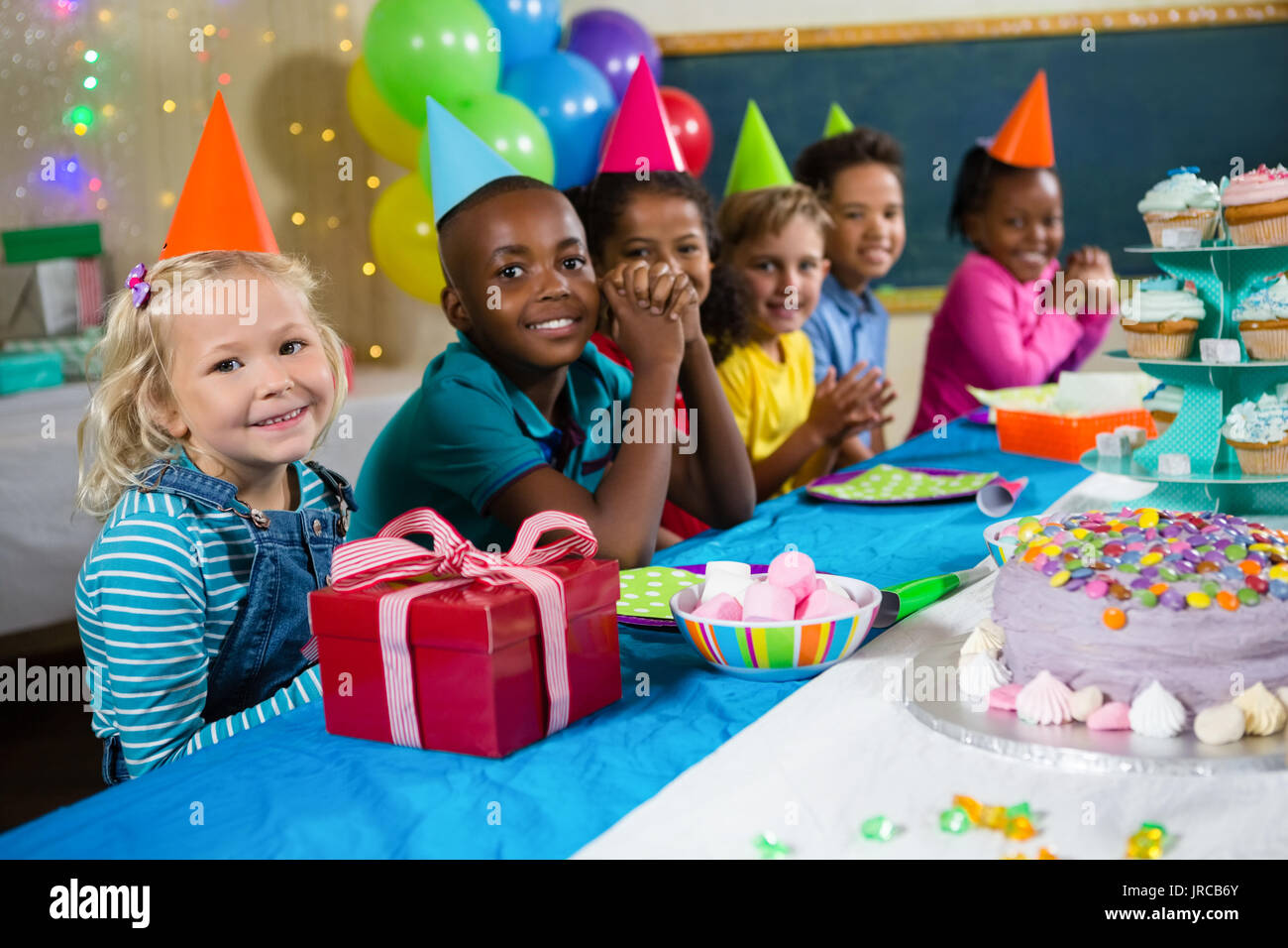 Portrait of children sitting at table during birthday party Stock Photo ...