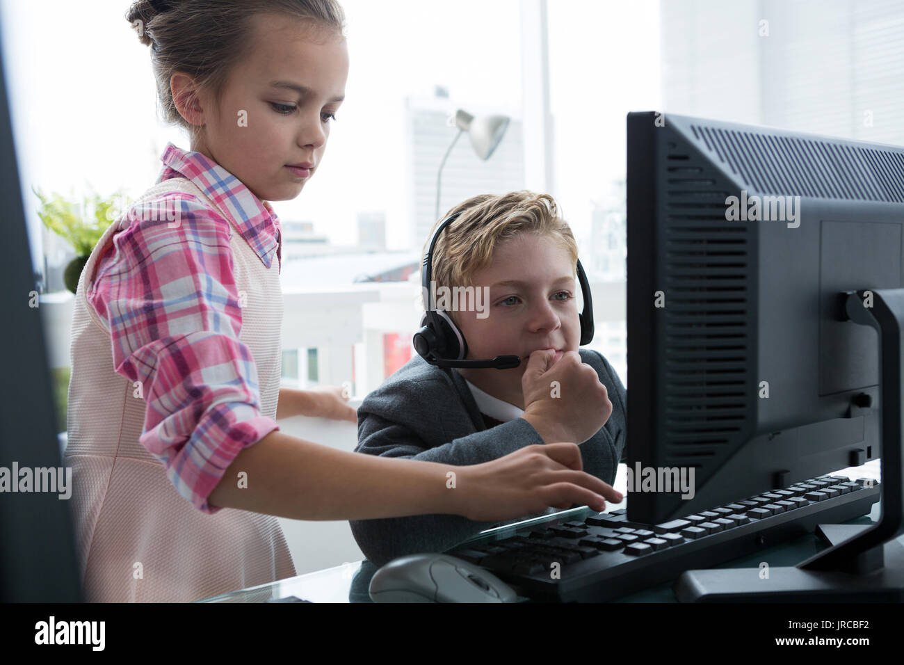 Kids using computer in office Stock Photo - Alamy