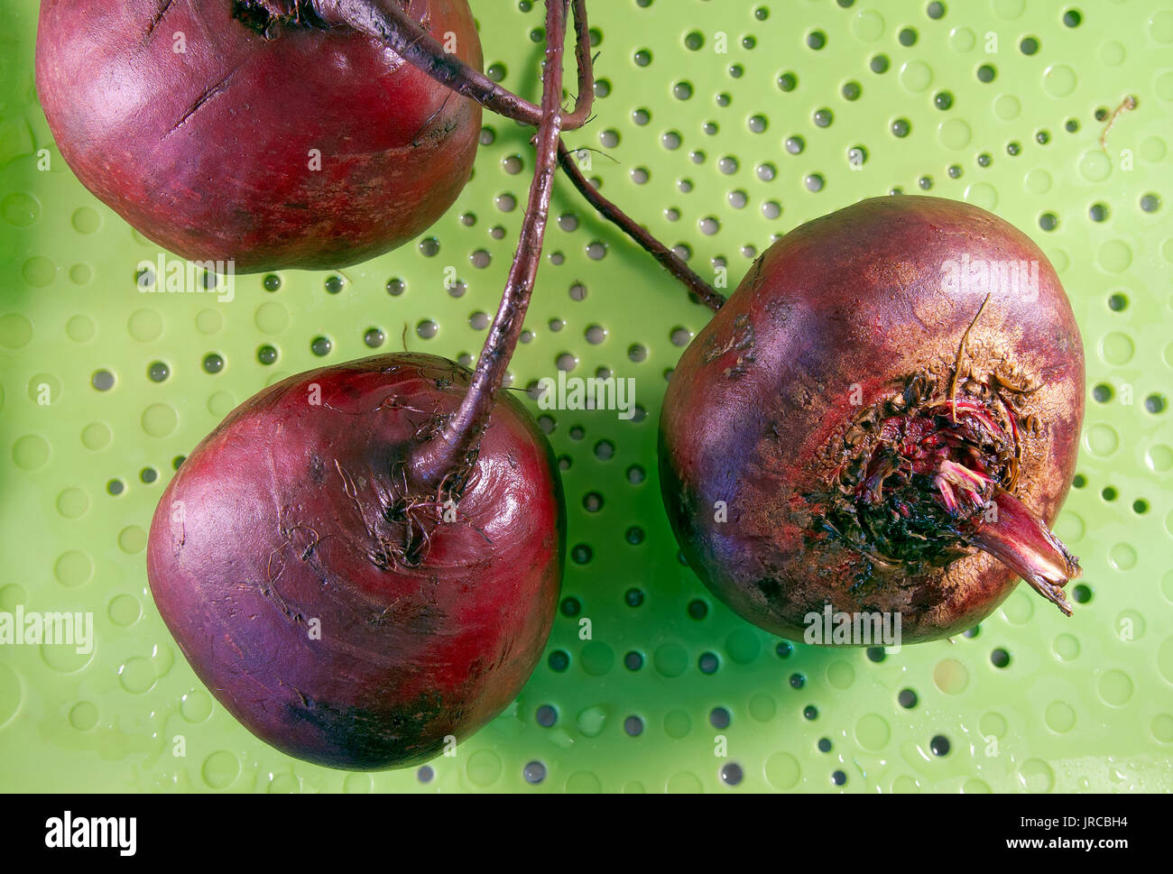Three wet beets on a green pallet Stock Photo - Alamy