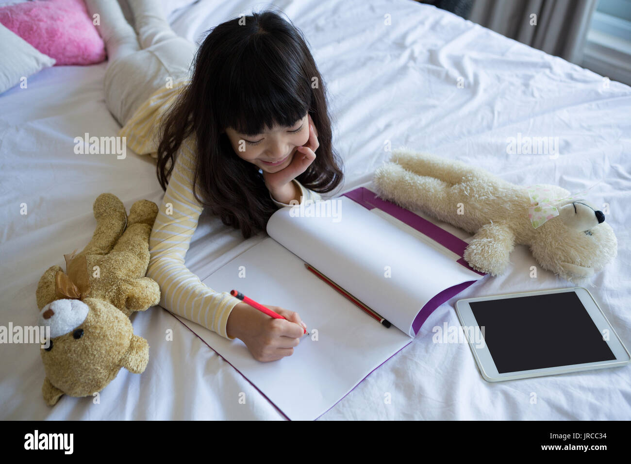 Girl lying on bed writing hi-res stock photography and images - Alamy