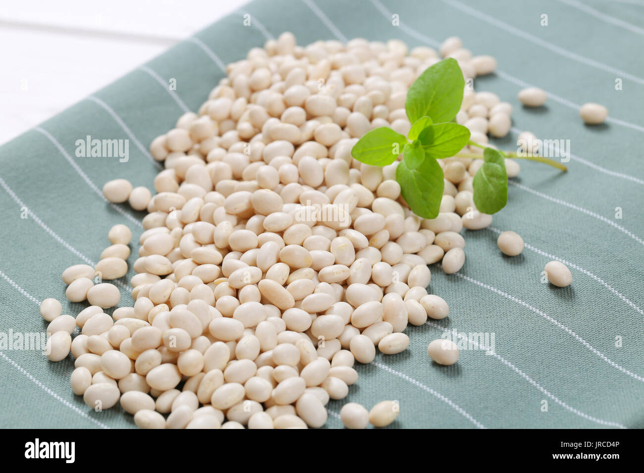 pile of raw white beans on grey place mat - close up Stock Photo - Alamy