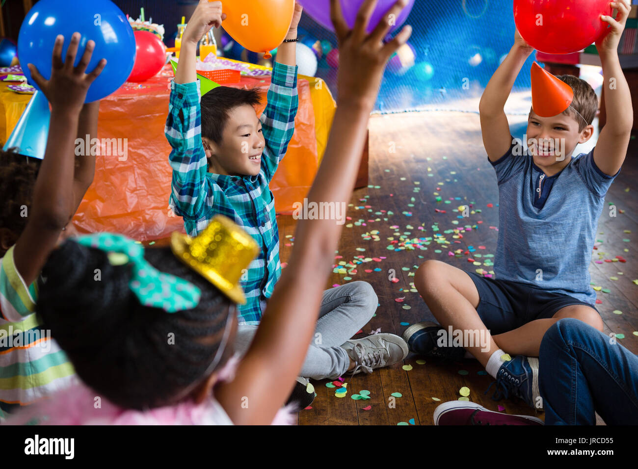 Cheerful children playing with balloon during birthday party Stock ...