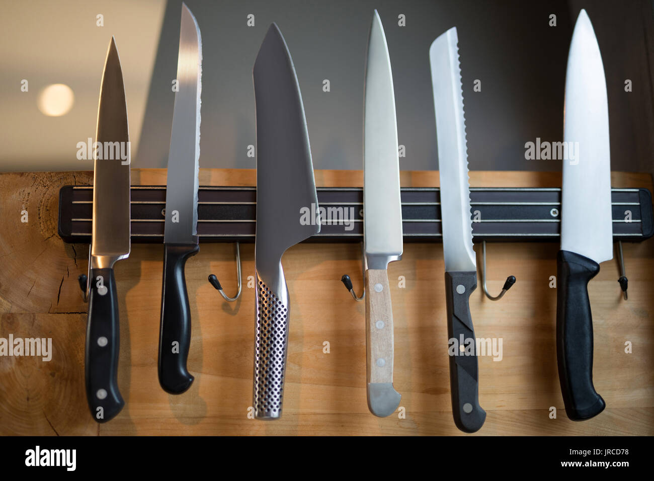 Close-up of kitchen knives hanging on the wall Stock Photo - Alamy