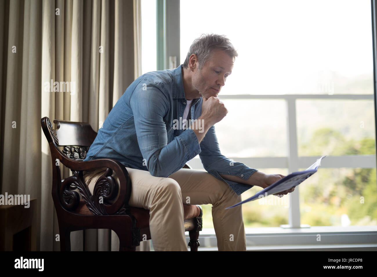 Man sitting chair reading newspaper hi-res stock photography and images ...