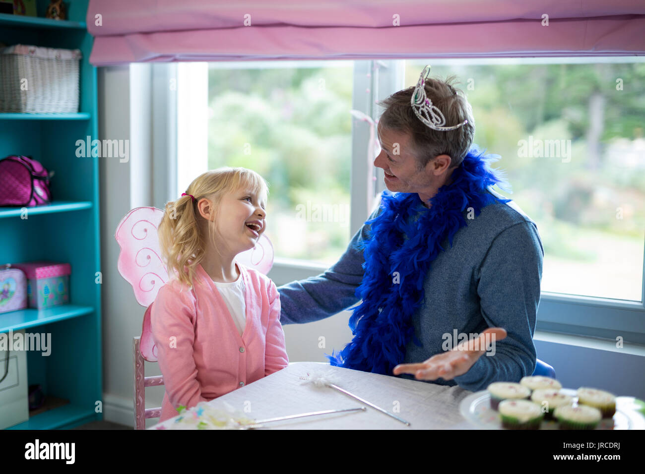 Smiling girl pretending to be a fairy playing with her father Stock ...