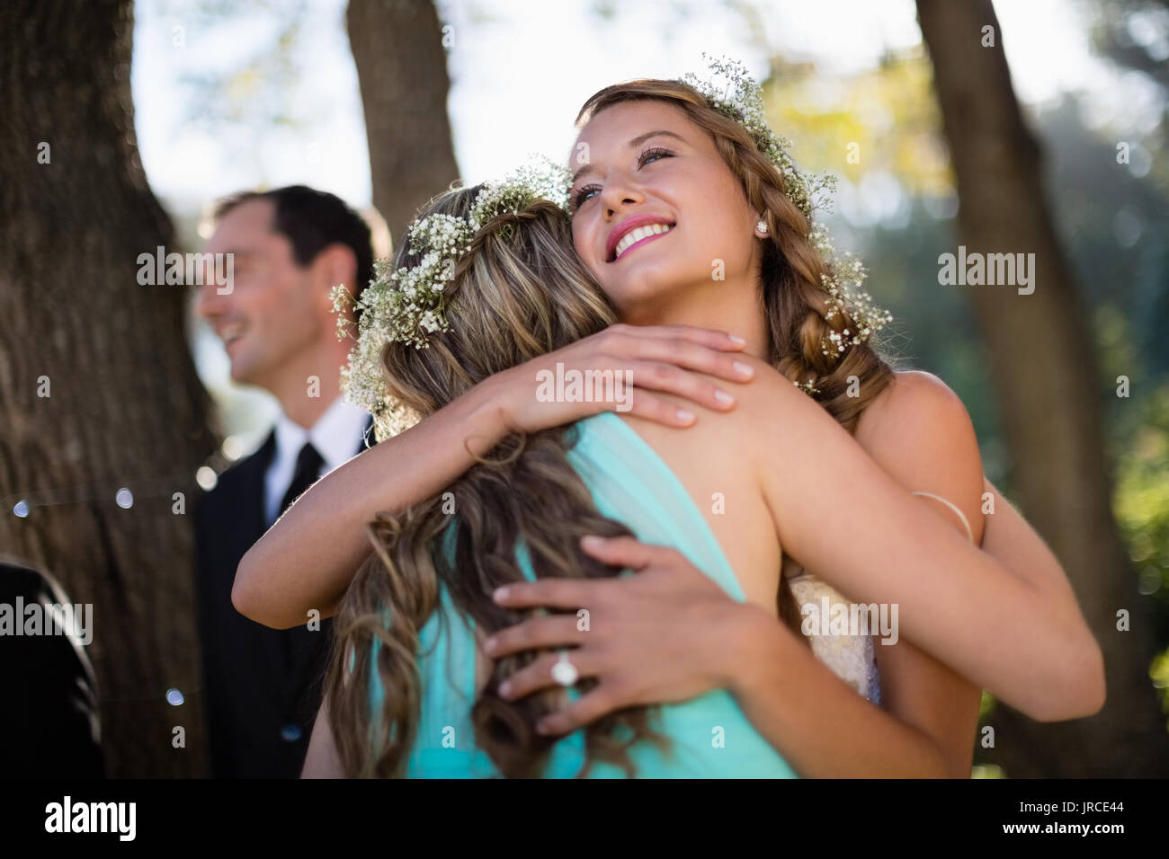 Bride embracing her friend in park during wedding Stock Photo - Alamy