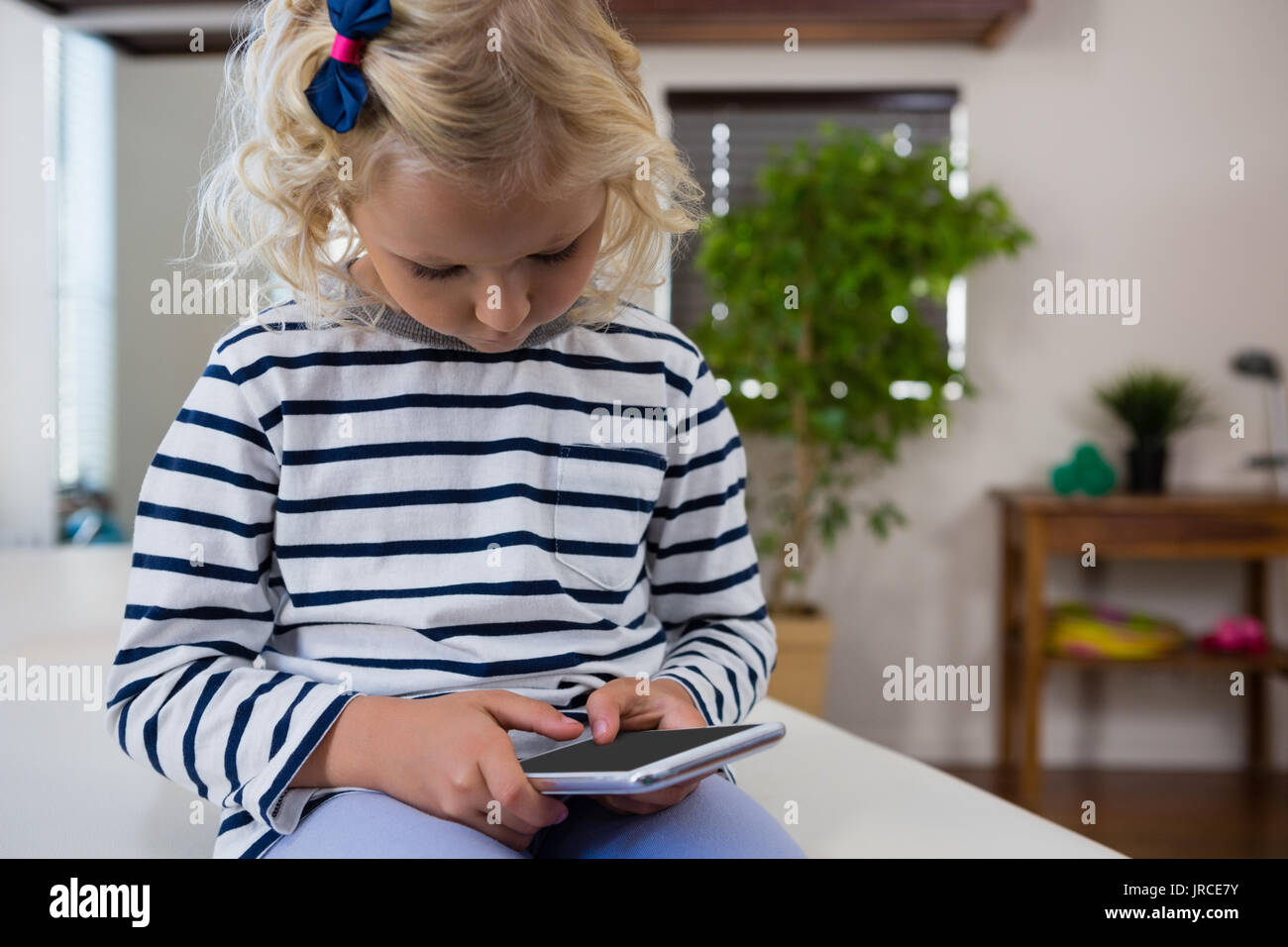 Girl using mobile phone in clinic Stock Photo - Alamy