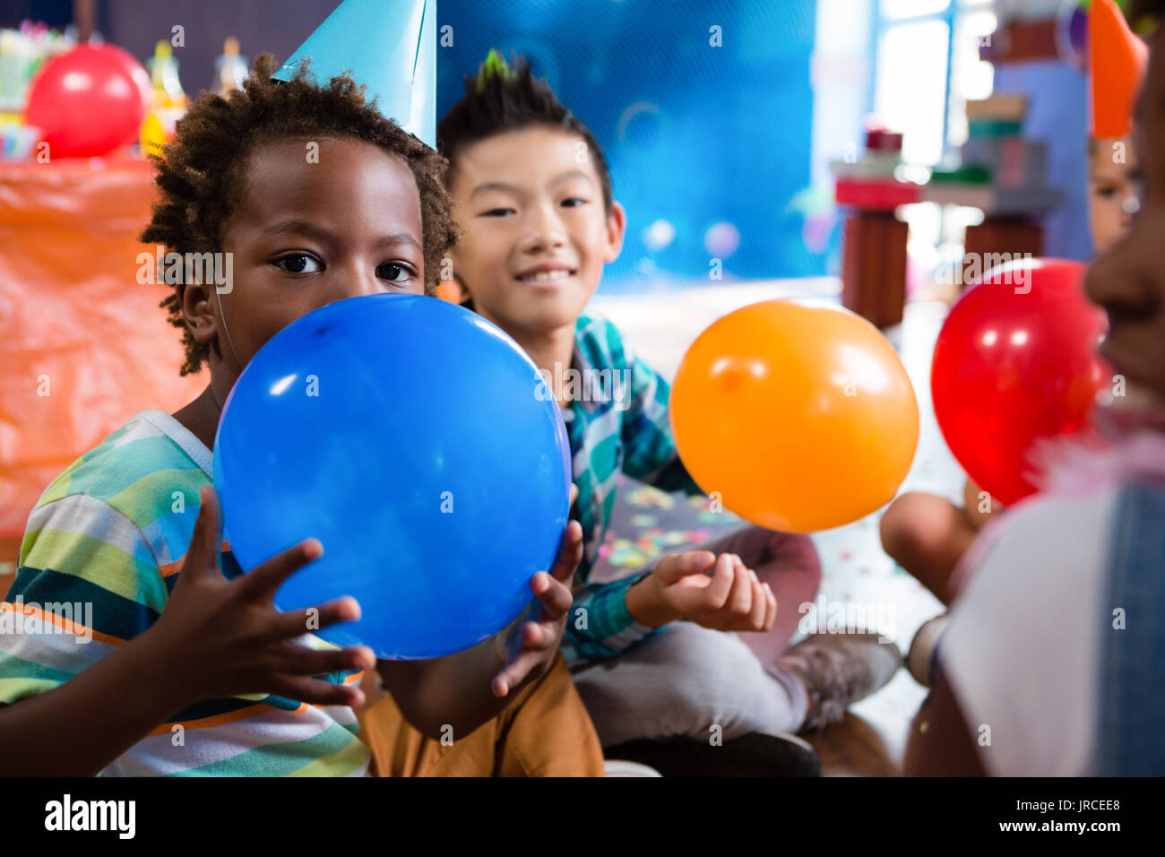 Portrait of children playing with colorful balloon in rood during party ...