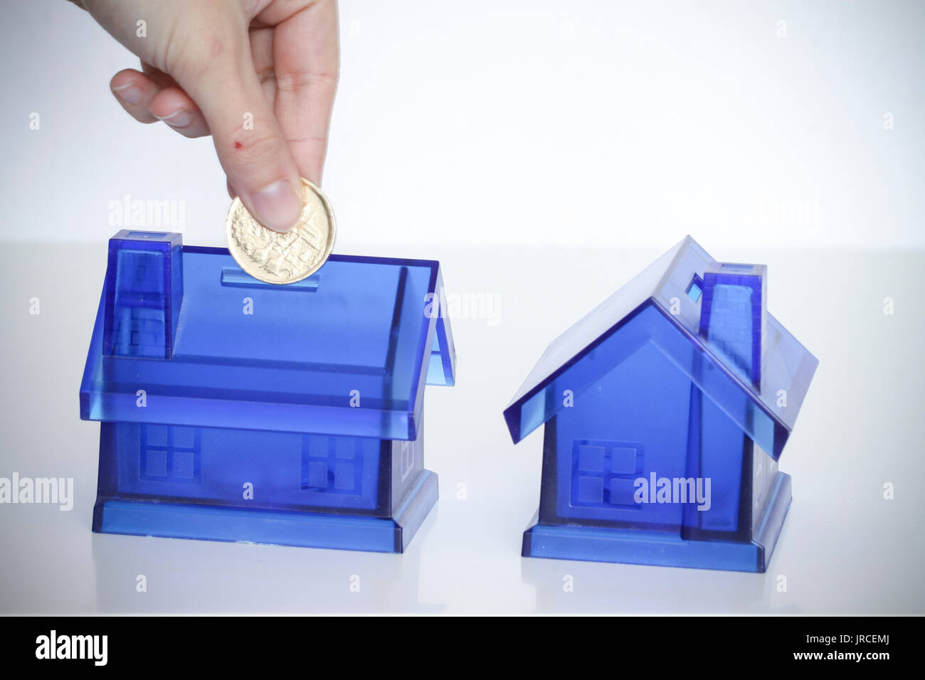 House Blue Money Box on White Background with woman hand with coin ...
