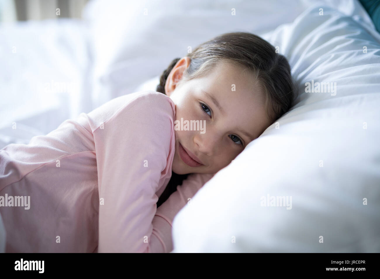 Portrait of smiling girl lying on bed in bedroom Stock Photo - Alamy