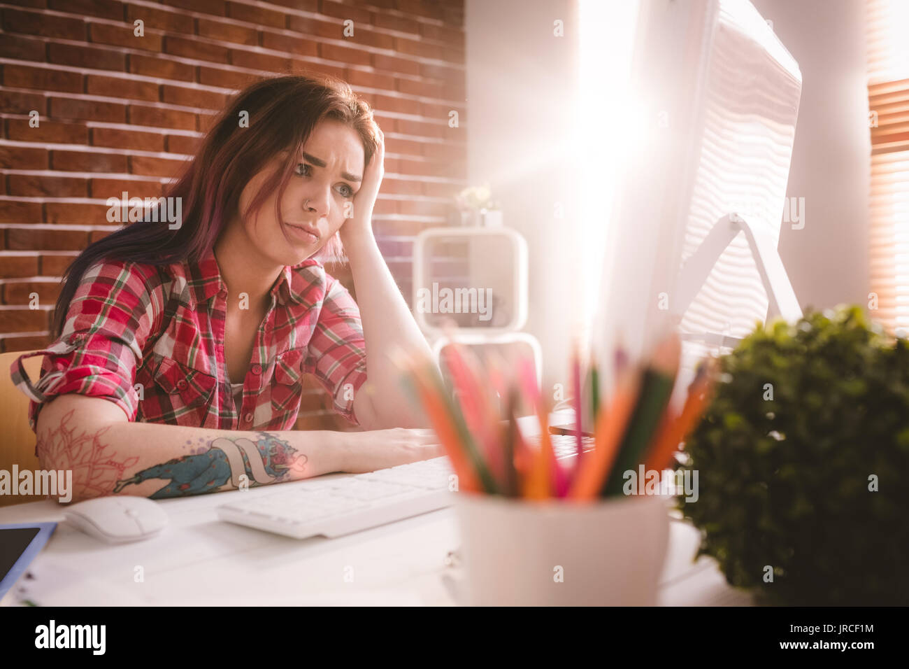 Tensed executive sitting with hand on forehead in office Stock Photo ...