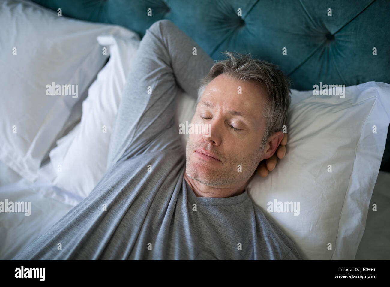 Man sleeping on bed in bedroom at home Stock Photo - Alamy