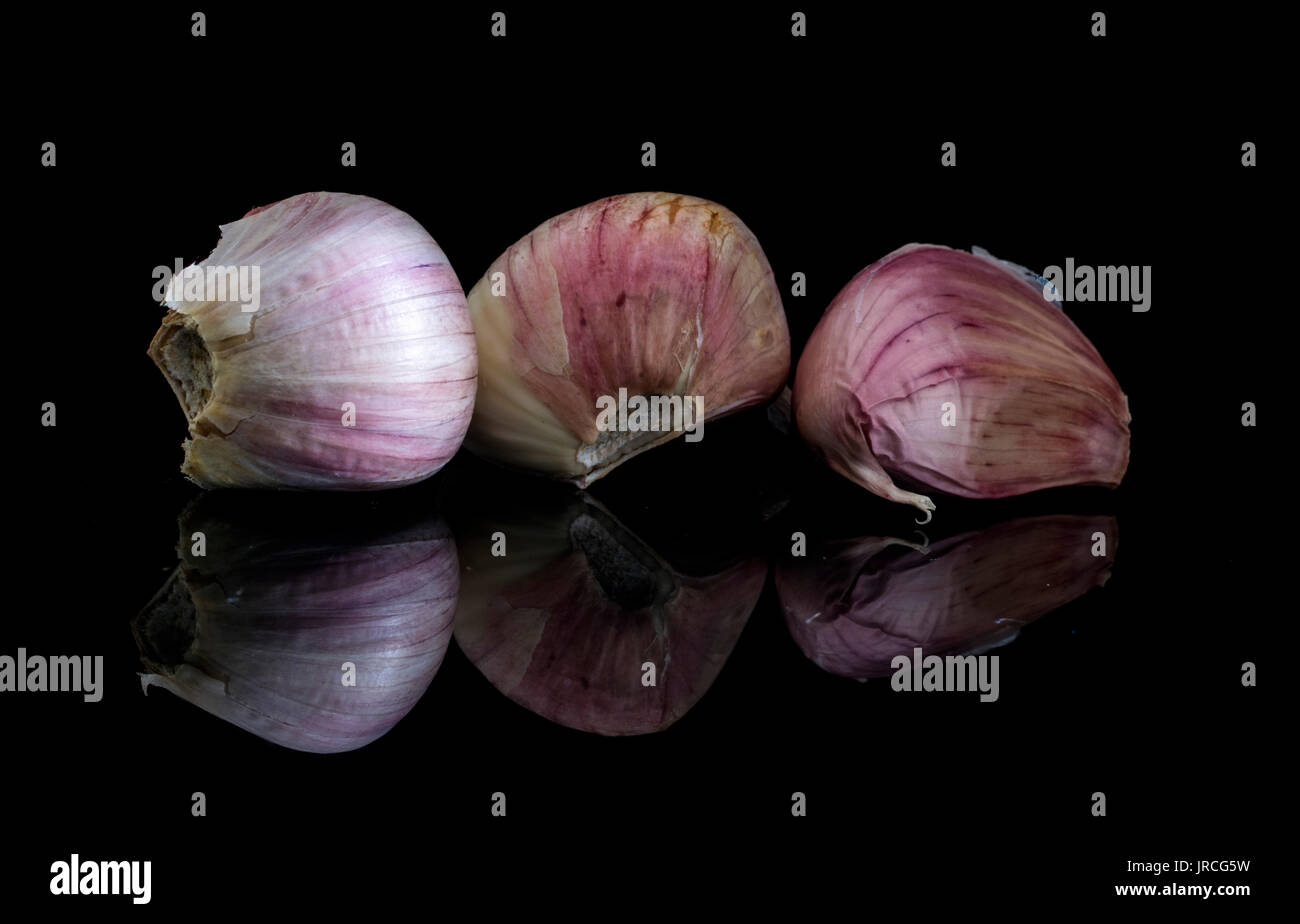 Fresh, raw and delicious garlic cloves spices on a black background and ...