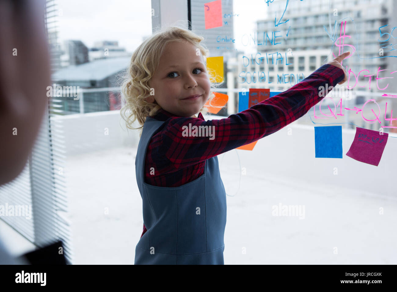 Businesswoman explaining to colleague while pointing at window in ...