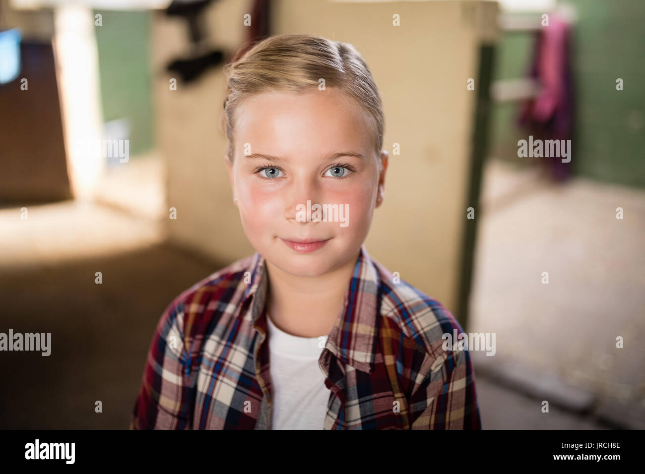 Portrait of smiling girl with blond hair standing in stable Stock Photo ...