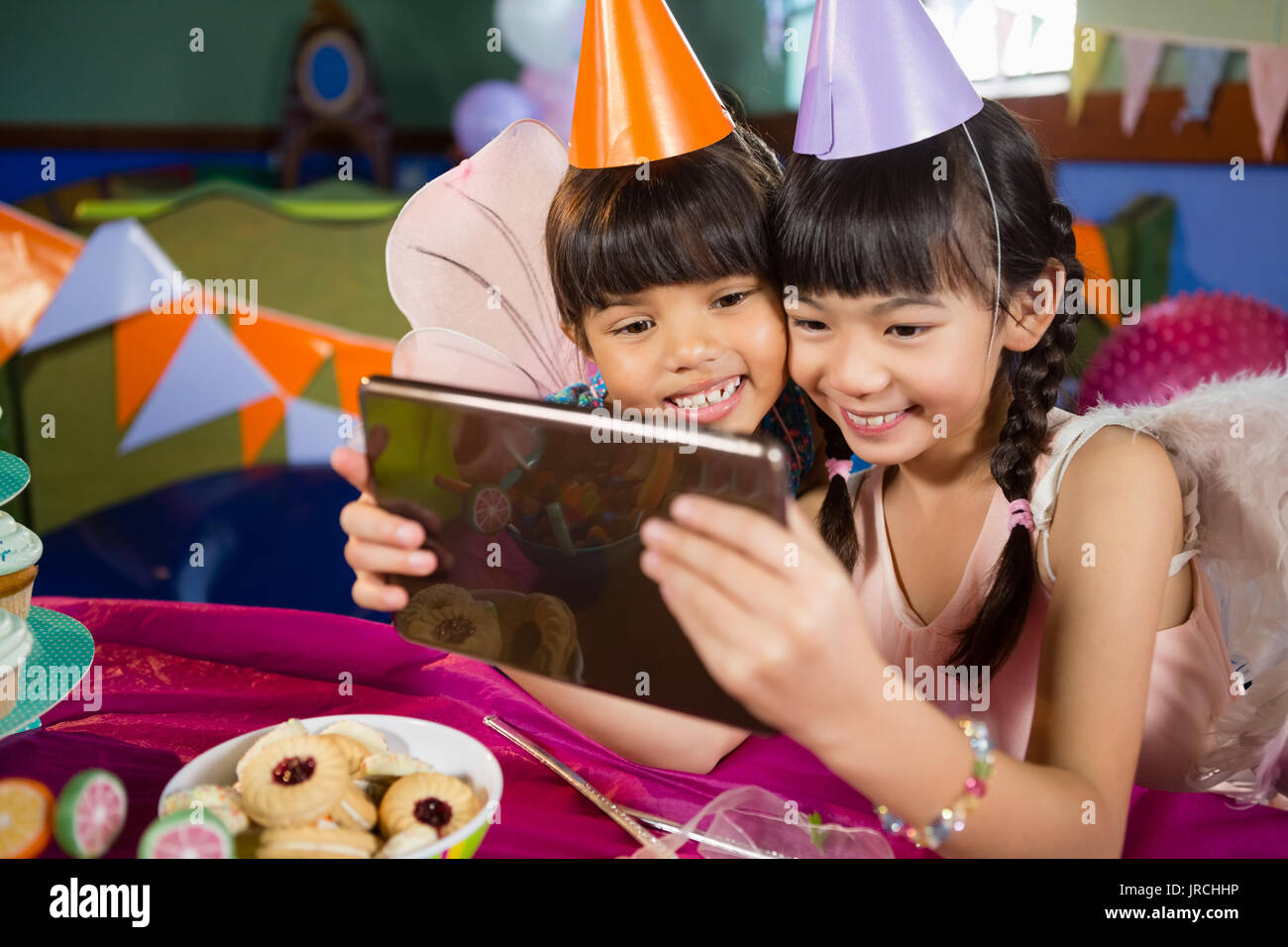 Kids using digital tablet during birthday party at home Stock Photo - Alamy