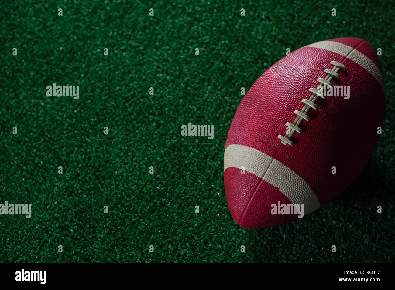 Close-up of American football on artificial turf against black ...