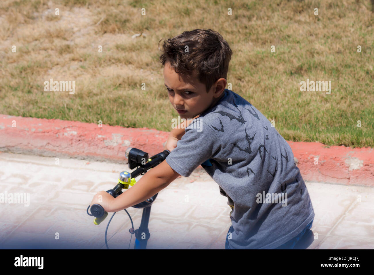 Angry child boy is riding bicycle Stock Photo - Alamy