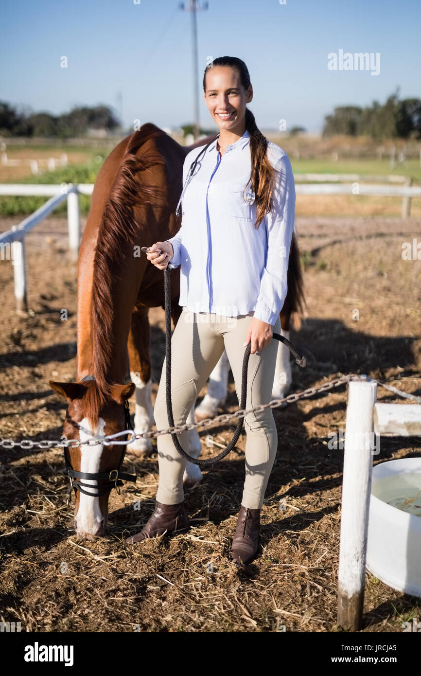 Full length portrait of vet standing by horse at barn Stock Photo - Alamy